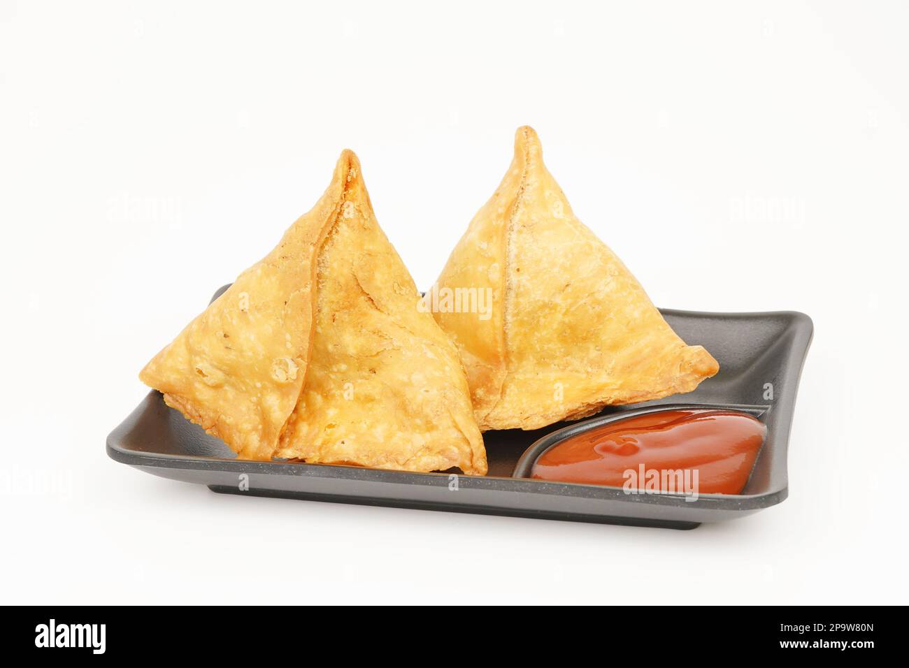 Closeup of samosa in plate isolated on white background Stock Photo - Alamy