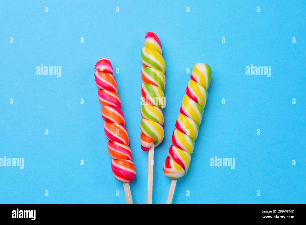 Sweet lollipops on light blue background, flat lay Stock Photo - Alamy
