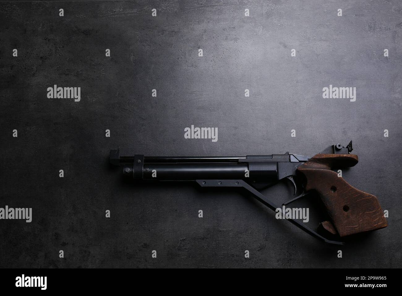 Sport pistol on black table, top view with space for text. Professional ...