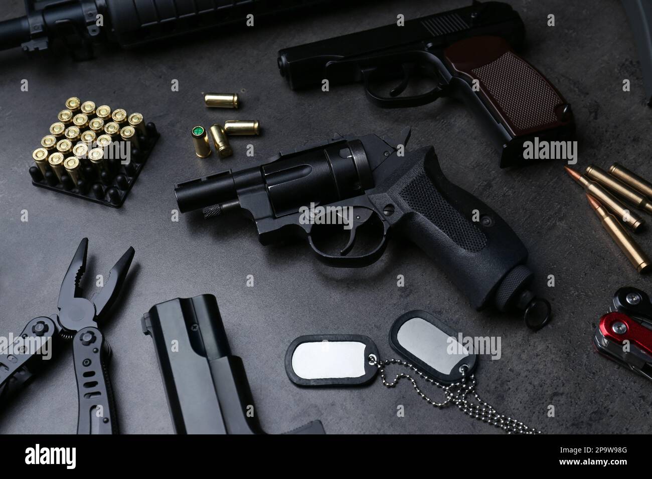 Composition with professional guns on black background, above view ...