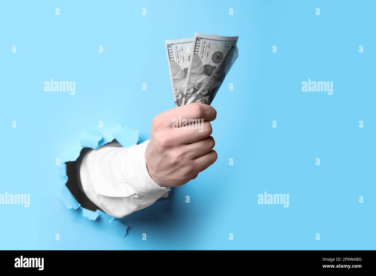 Hand breaking through paper holding hi-res stock photography and images ...