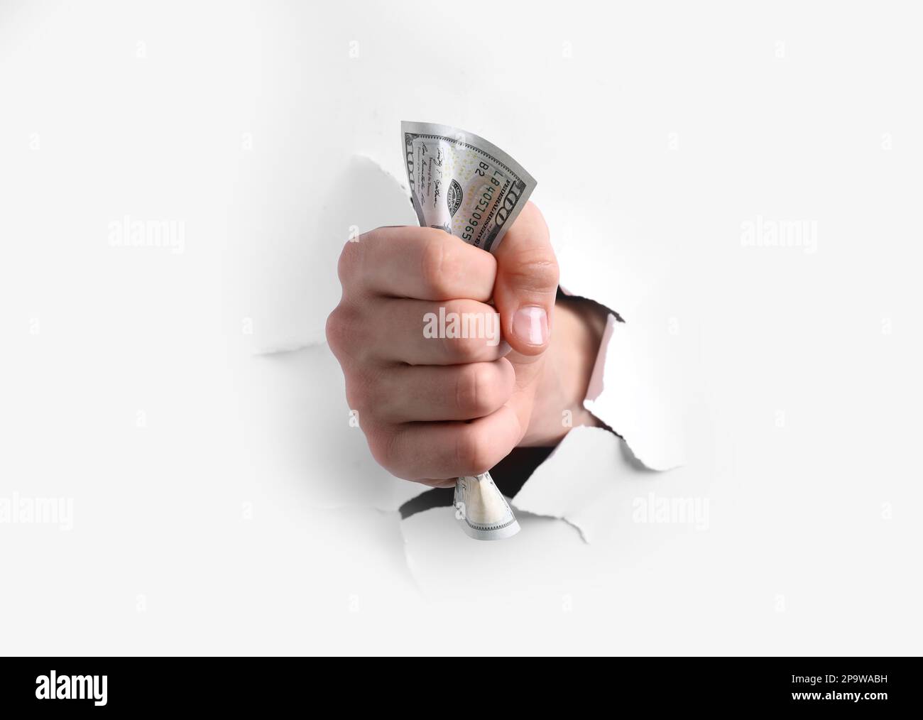 Man breaking through white paper with money in fist, closeup Stock ...
