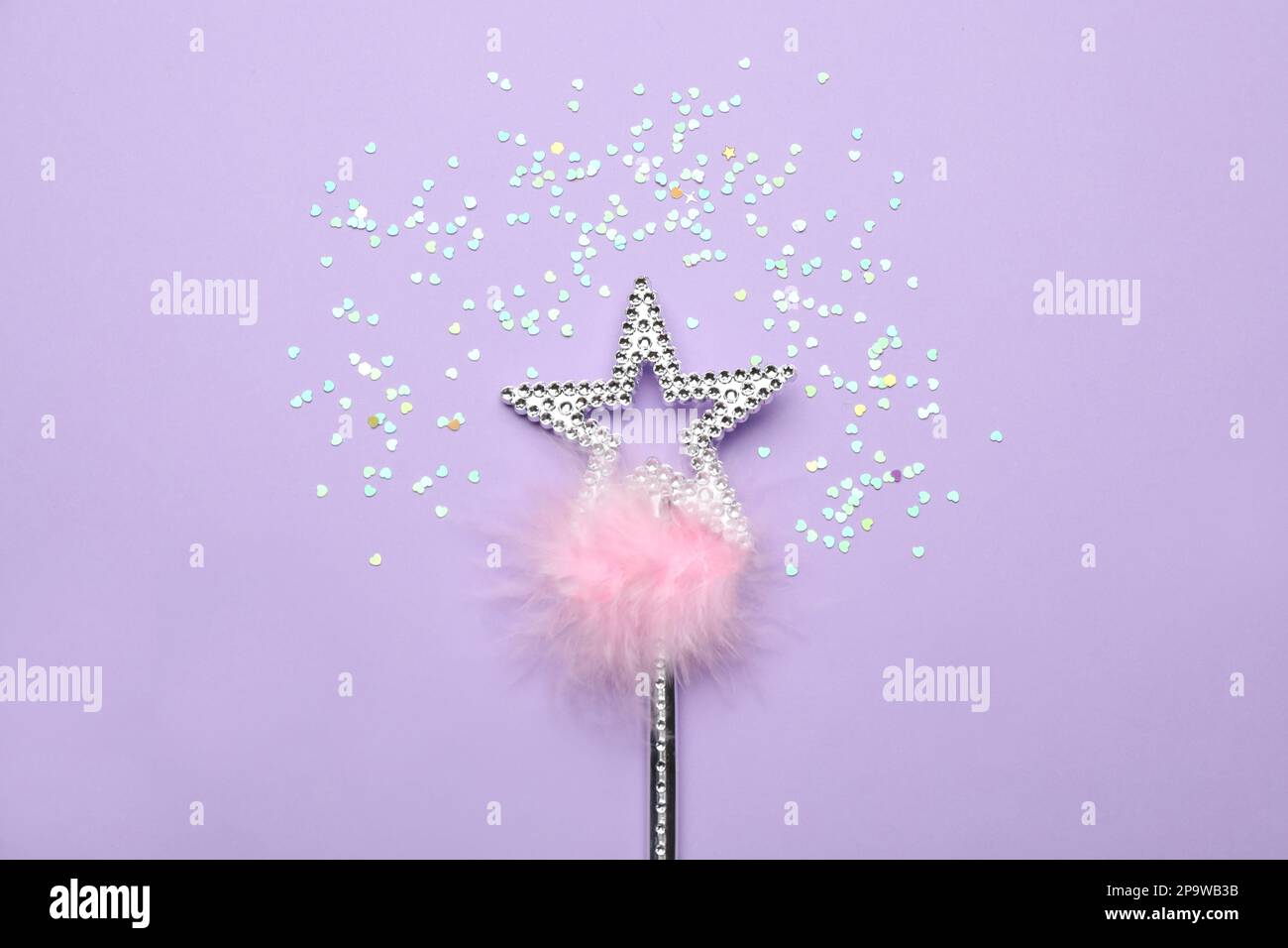 Beautiful silver magic wand with feather and confetti on lilac ...