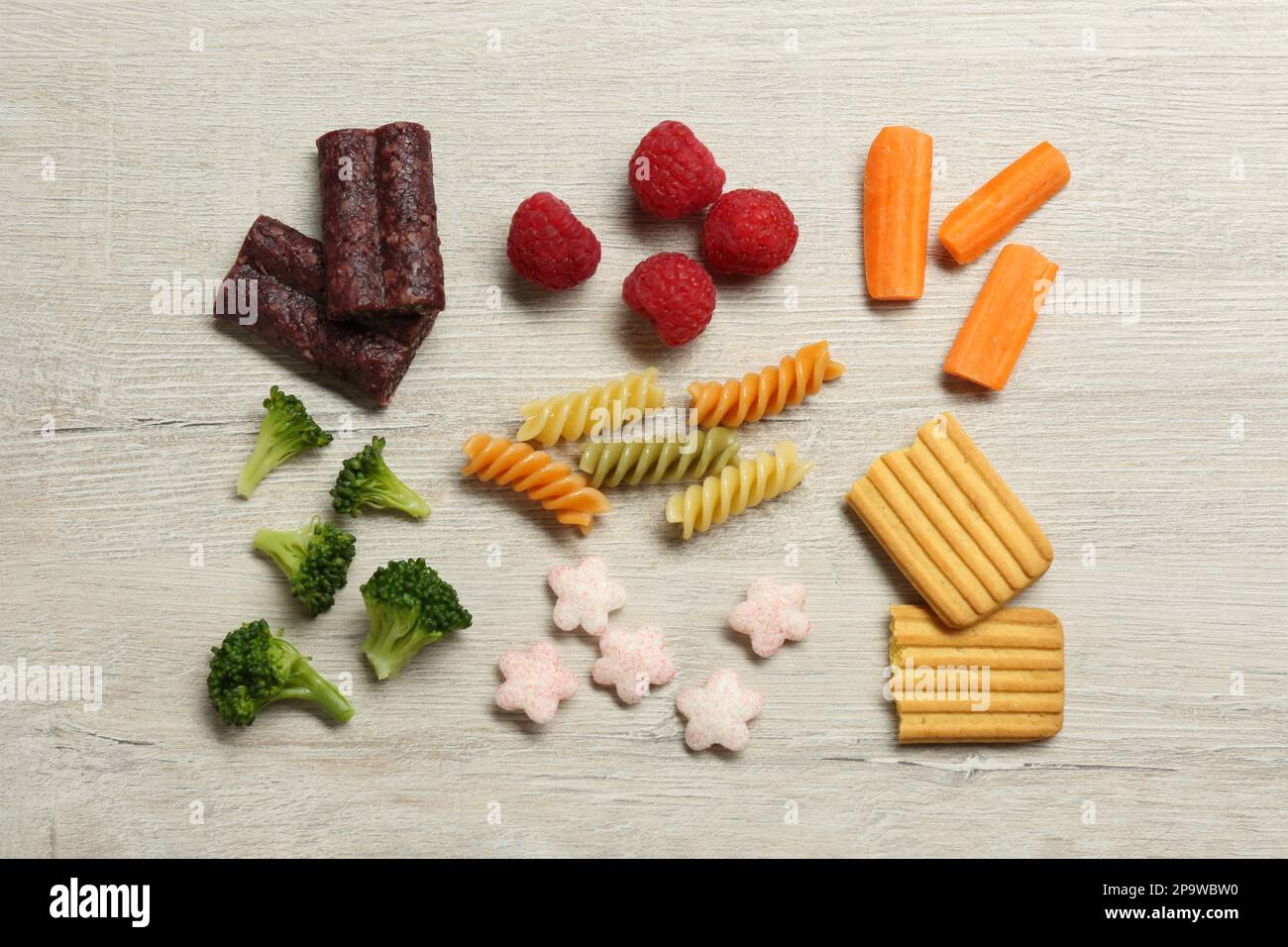 Set of different finger foods for baby on beige wooden table, flat lay ...