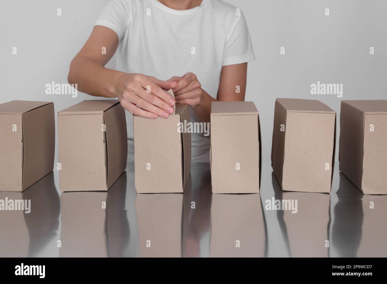 Woman folding cardboard boxes hi-res stock photography and images - Alamy