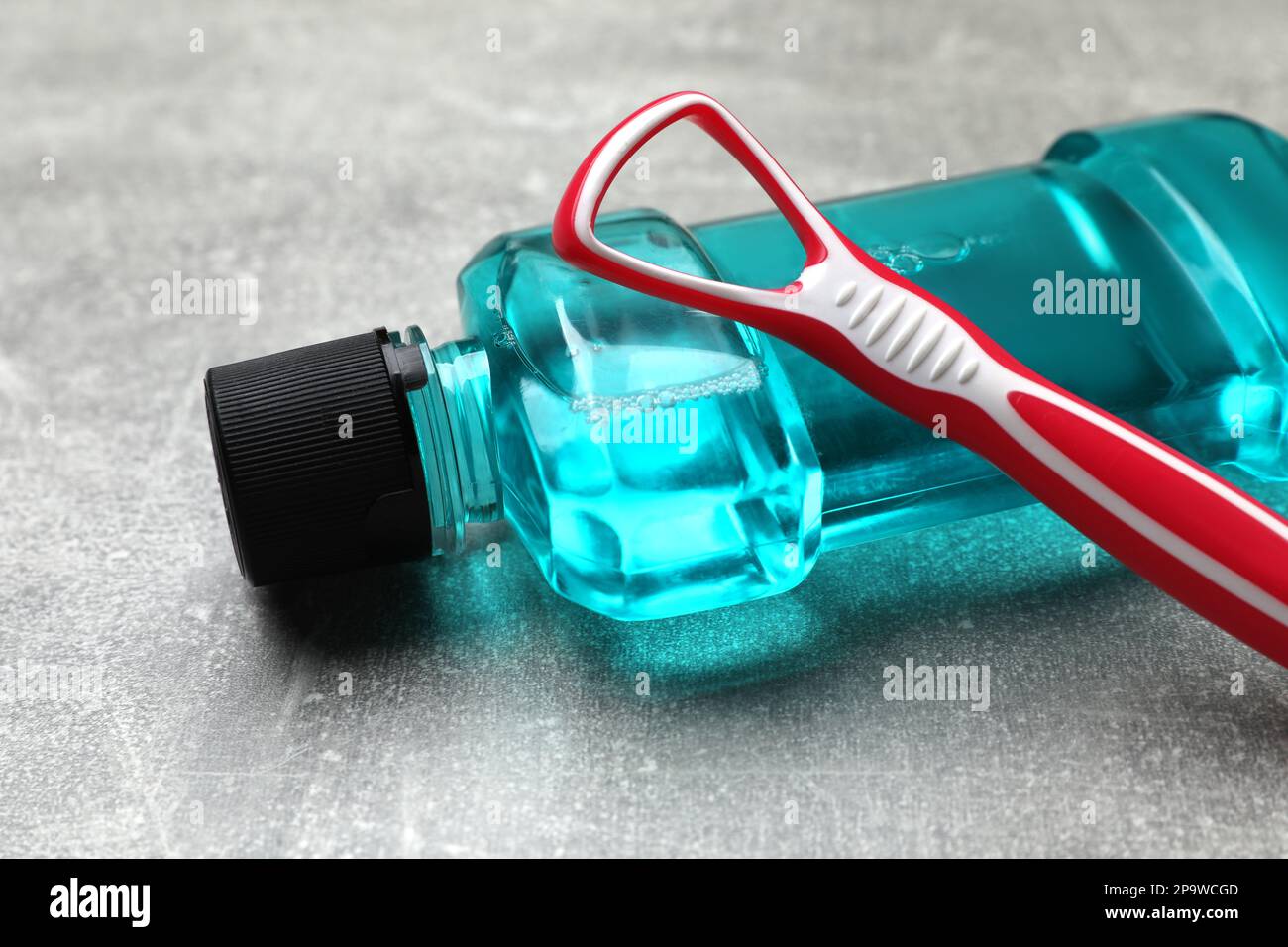 Red tongue cleaner and mouthwash on grey table, closeup Stock Photo - Alamy