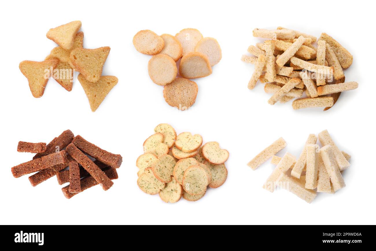 Set with different delicious crispy rusks on white background, top view ...