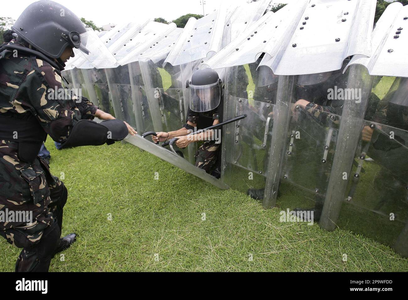 A Philippine army officer grabs the shield of an anti-riot soldier ...