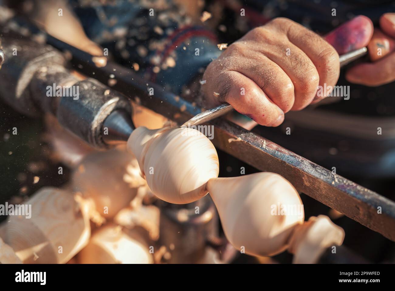 Handmade production stage of spinning top. A woodcarver carving the ...