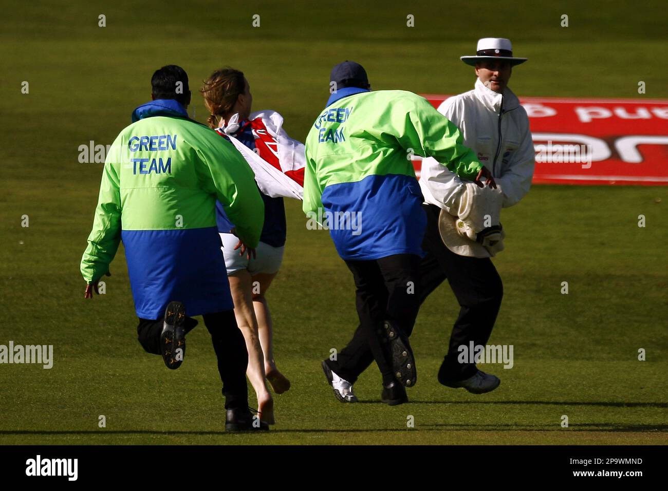 Umpire Billy Bowden, right, moves out of the way as stewards chase down ...