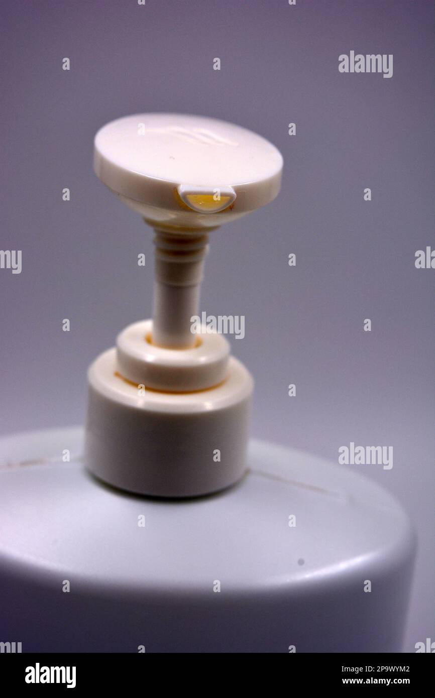 A large white plastic bottle with a large dispenser for cosmetics ...