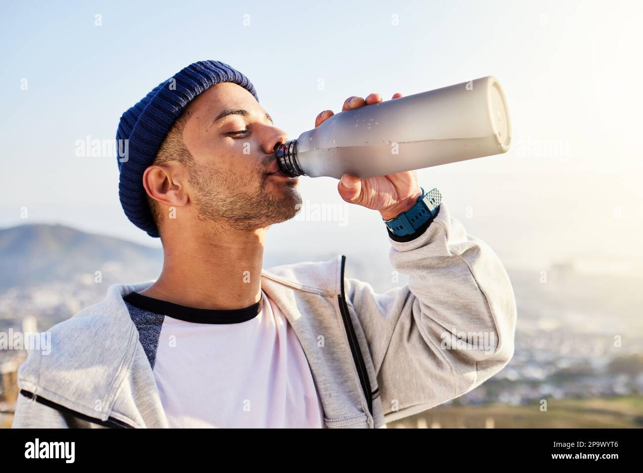 Man drinking water, runner in city with fitness and health, thirsty and ...