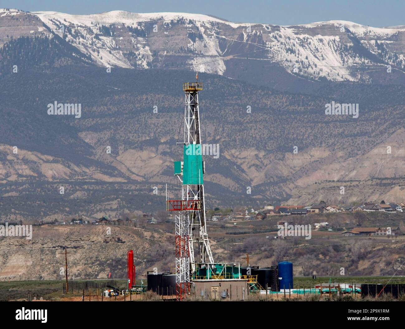 With the Roan Plateau in the background, a natural gas wellhead works ...
