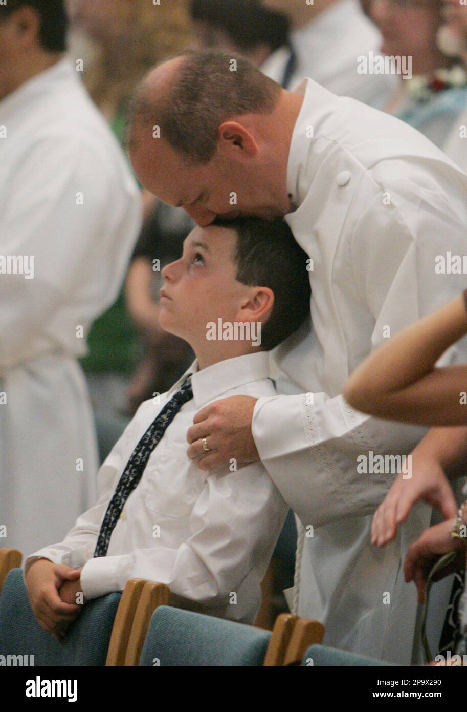 ** ADVANCE FOR FRIDAY, JULY 18 **Deacon David Henn comforts his son ...