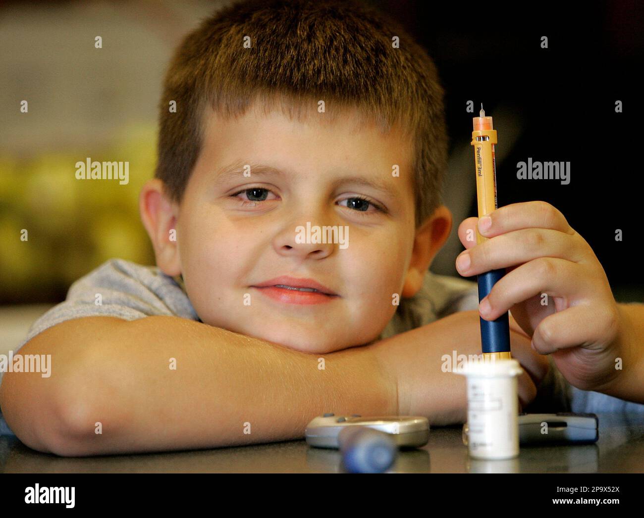 Brandon Merrell, 8, holds his insulin needle at his home Friday, July ...