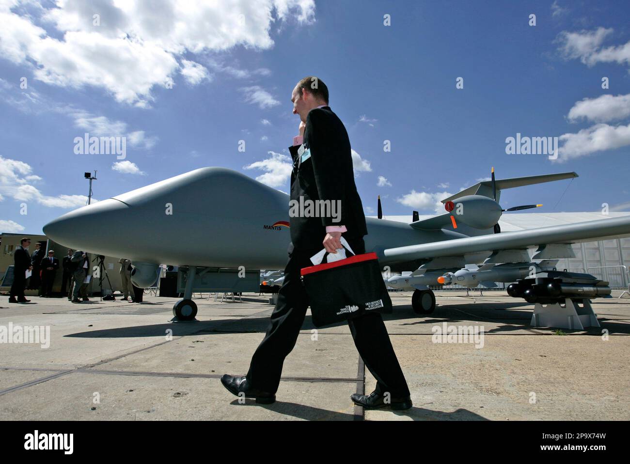 A visitors walk past a Mantis unmanned aircraft made by BAE Systems PLC ...