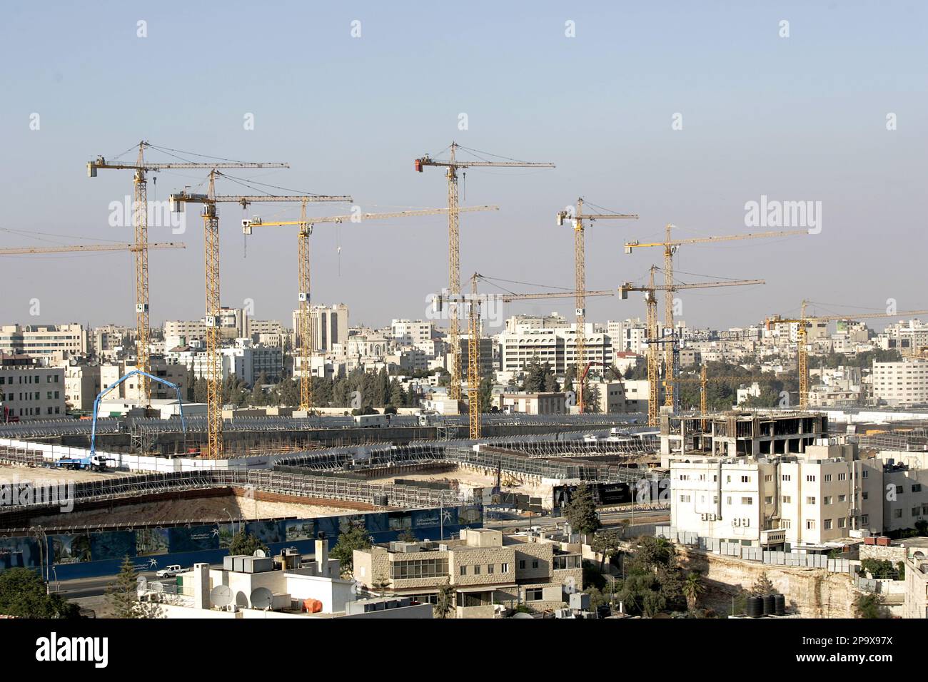 Cranes stand over a construction site where residential skyscrapers ar ...