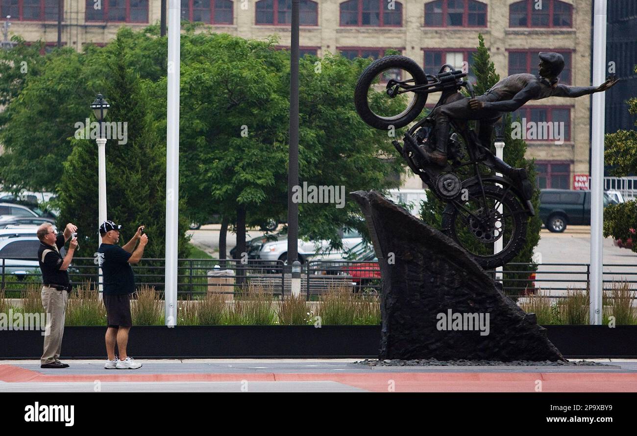 Motorcycle enthusiasts take pictures of a statue outside the Harley ...