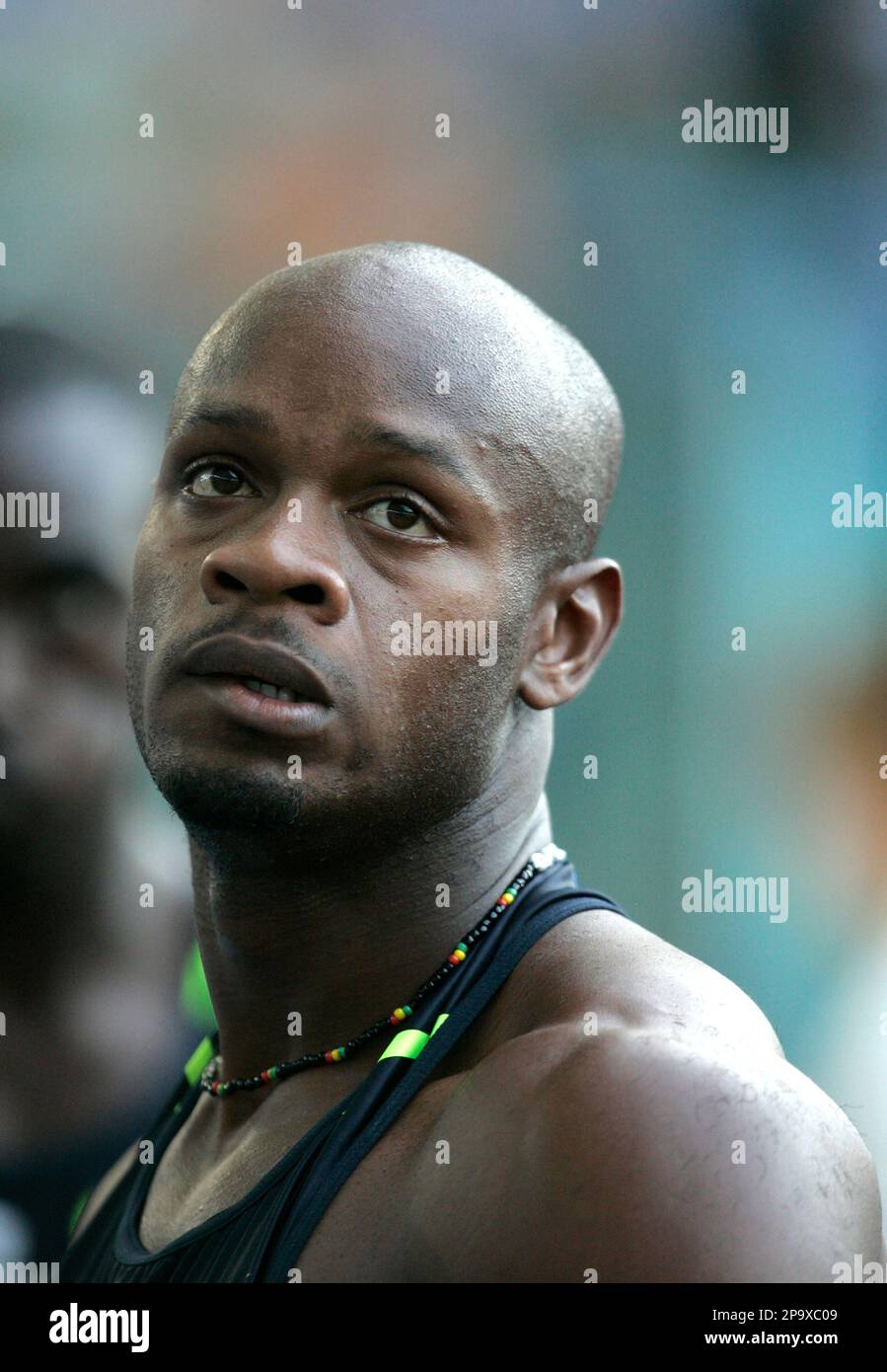 Asafa Powell from Jamaica reacts after running the first heat of the ...