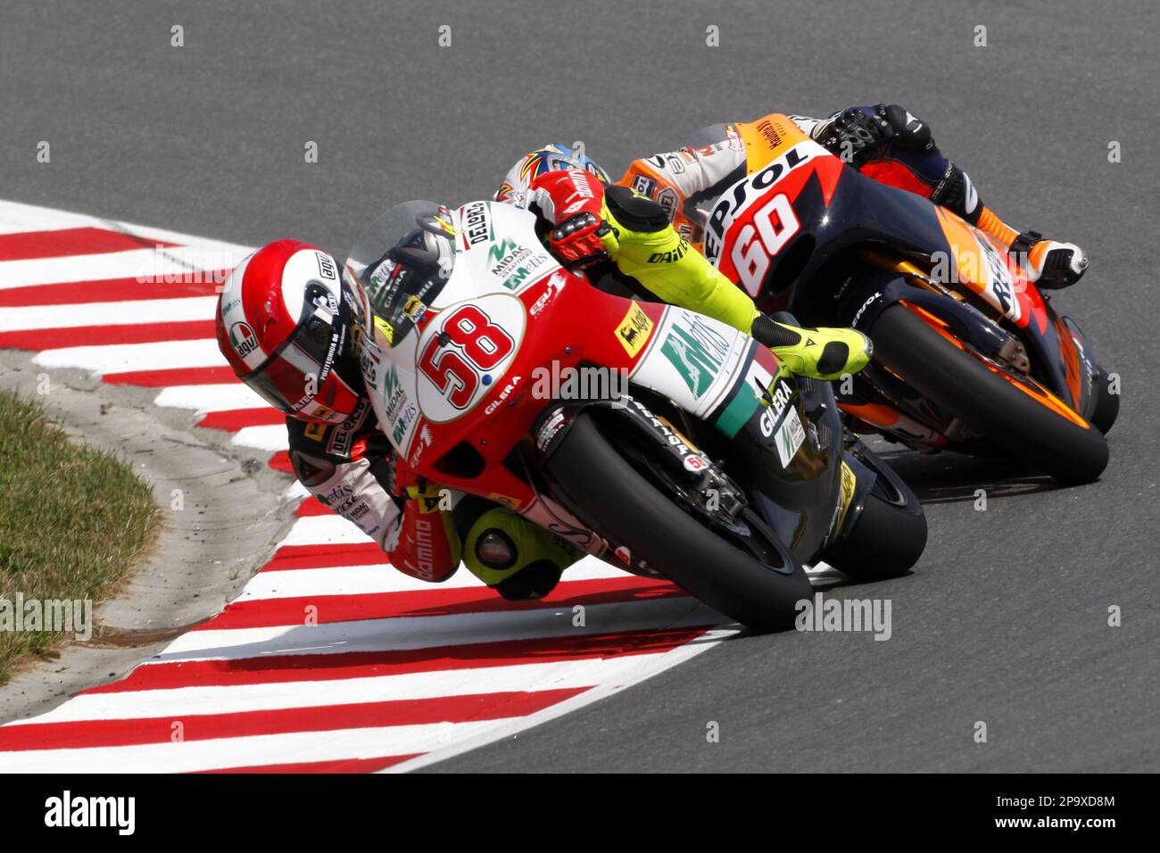 Italian Gilera rider Marco Simoncelli, front, rides his bike into a ...
