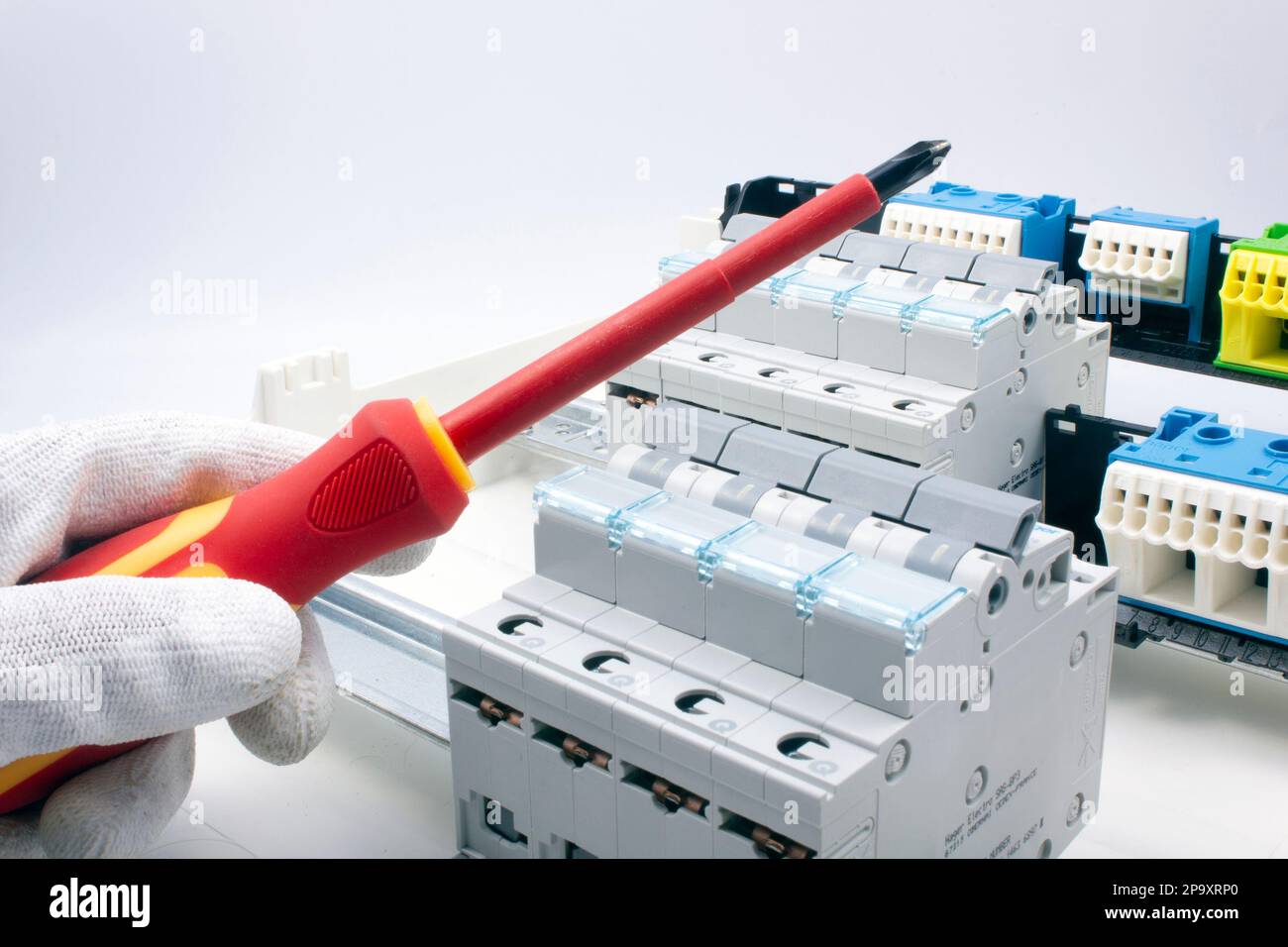 An electrician installs fuses on the TH35 rail in the electrical ...