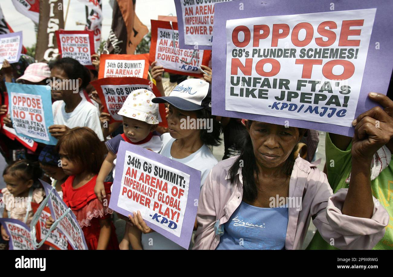 Anti-G8 Filipino protesters hold slogans in front of the Japanese ...