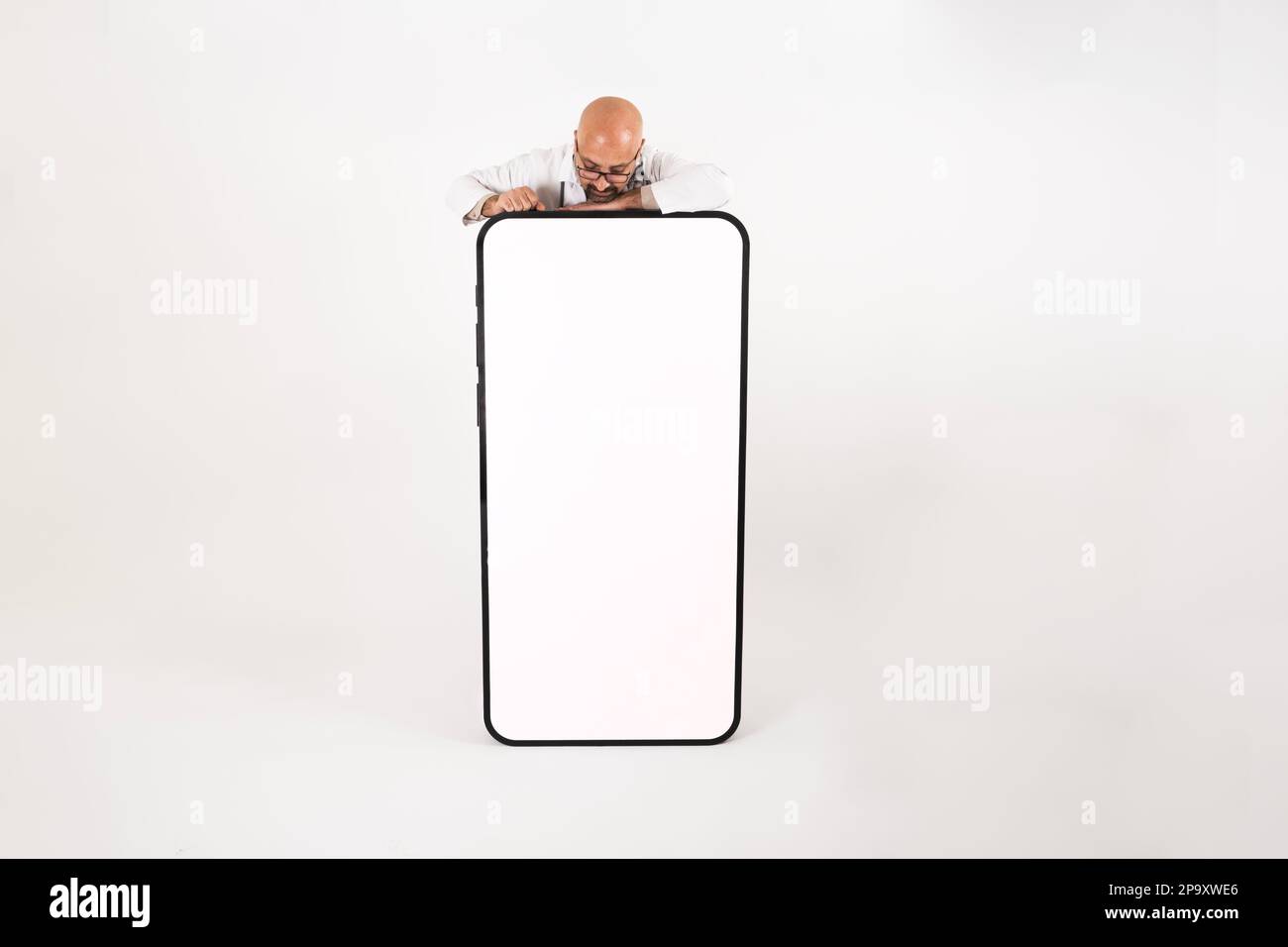 Man leaning big smartphone mock up from behind. Light gray background ...