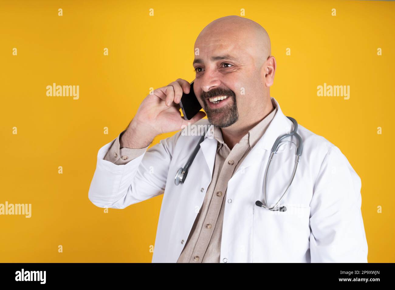 Hospital professional talking on the phone. Smiling with sincerely ...
