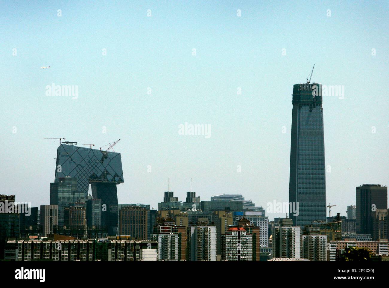 A passenger airliner fly past the ongoing construction of the city ...