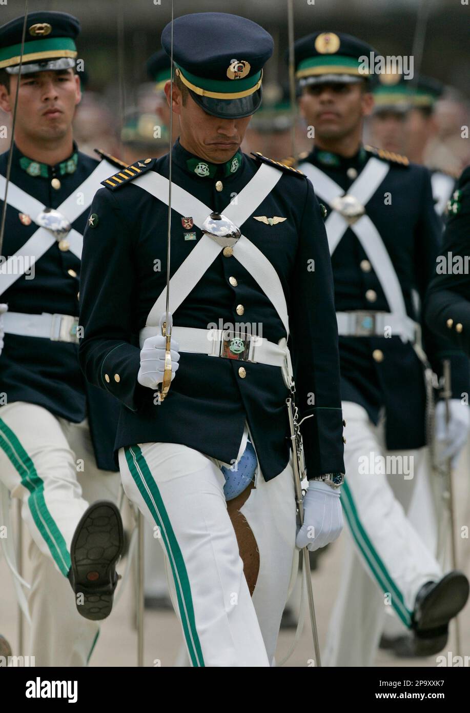 An Army cadet looks down at his ripped uniform pants as he marches in a ...