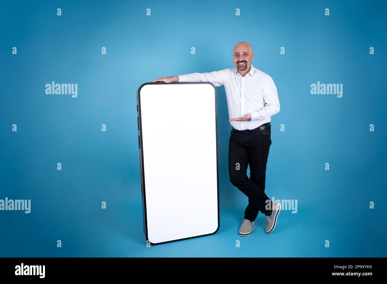 Happy man leaning full body length of big cell phone. Modern smartphone ...