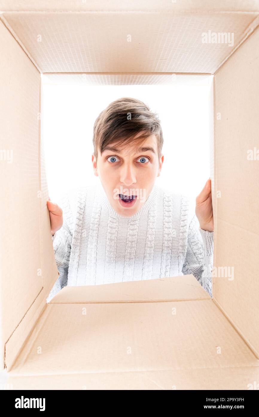 Happy and Surprised Young Man looking inside a Box Stock Photo - Alamy