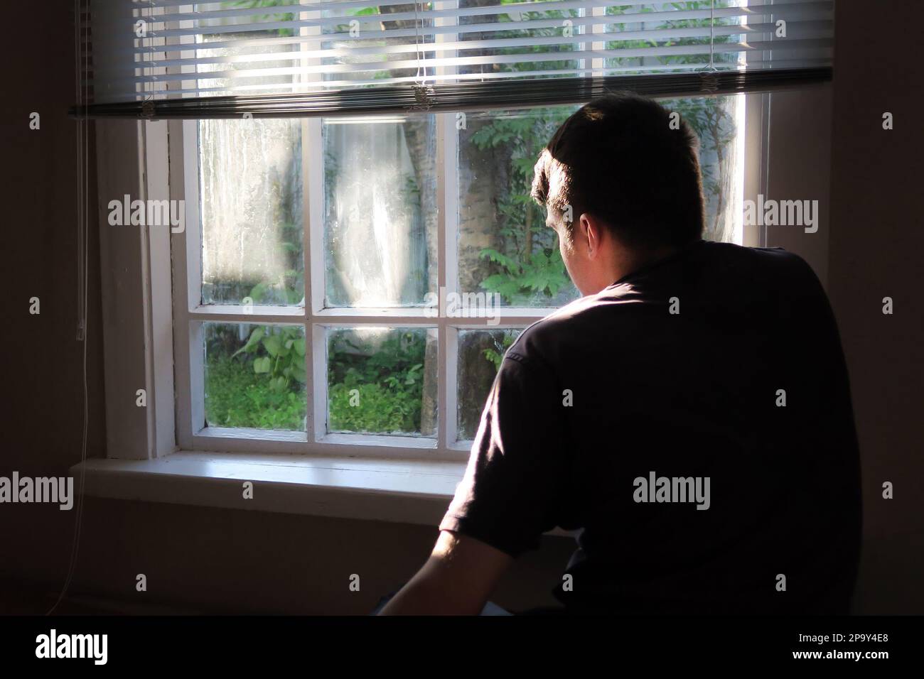 Sad and Lonely Young Man sit near the Window at the Home Stock Photo ...