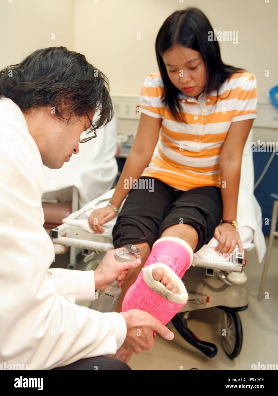 Dr. Terry Amaral removes post-surgical casts from the feet of the ...