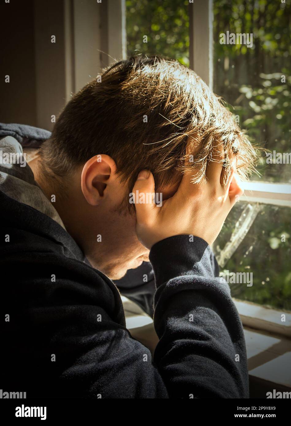 Sorrowful Young Man by the Window in the Room Stock Photo - Alamy