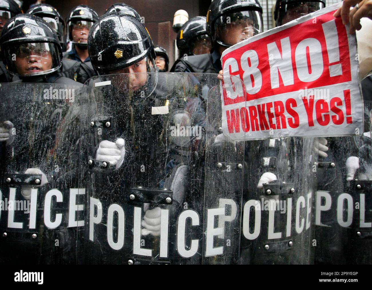 An activist shows holds up a campaign placard in front of a line of ...