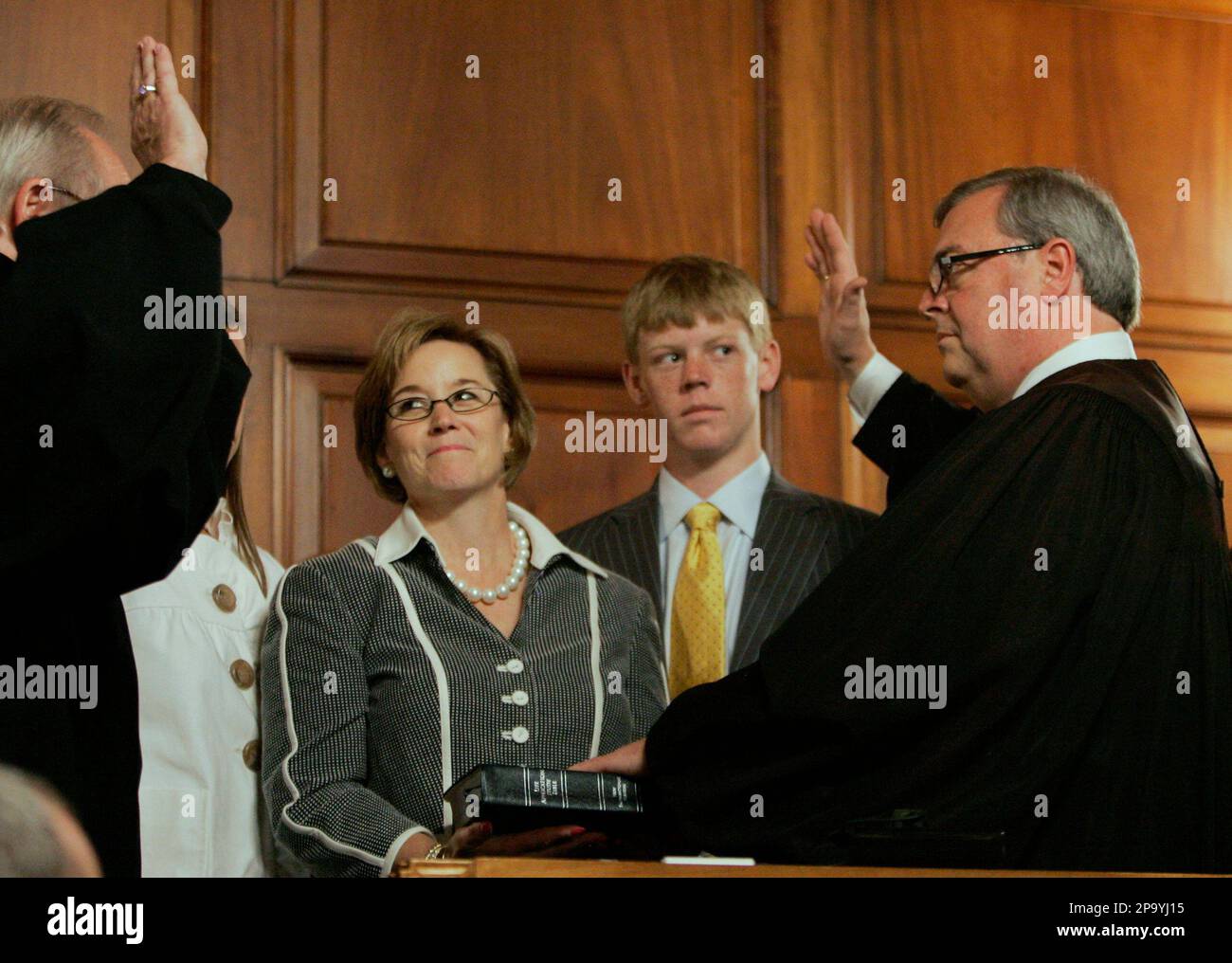 With his wife Susan holding the Bible and son John looking on, John D ...