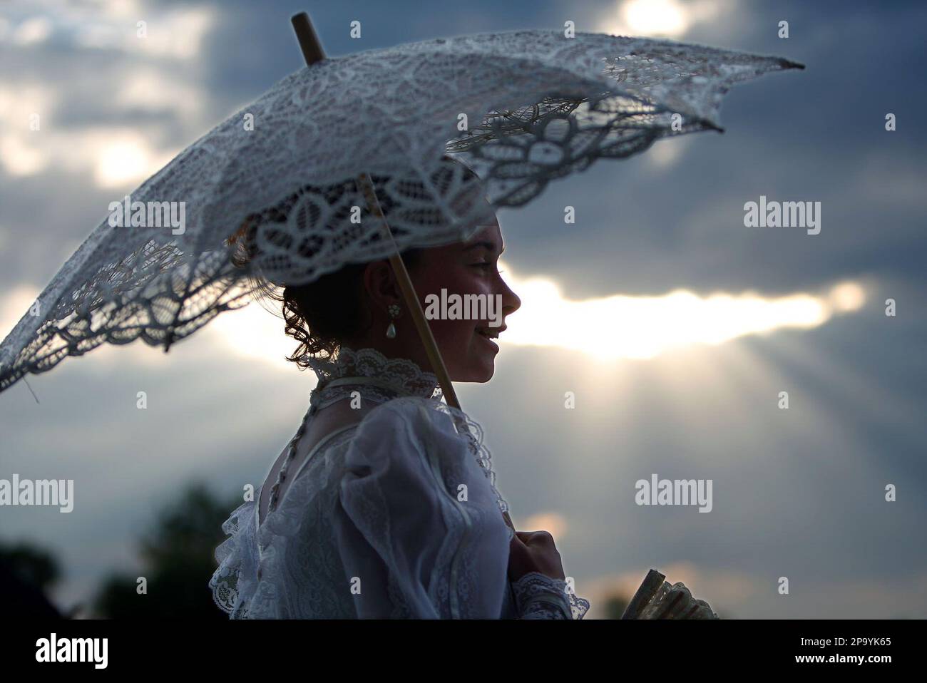 Mallory Edgar, 14, of Hardin, Mont., holds her parasol as she waits for ...
