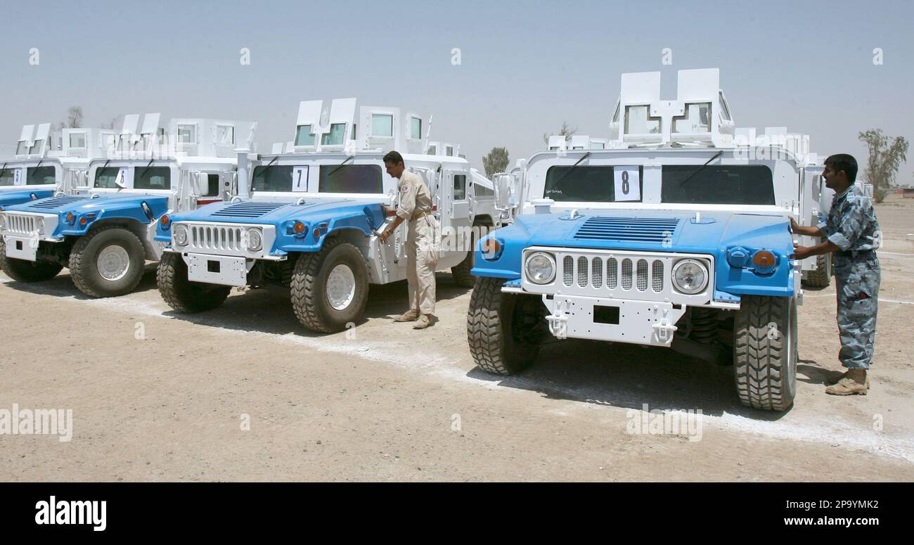 Iraqi police officers stand next armoured vehicles during a ceremony to ...