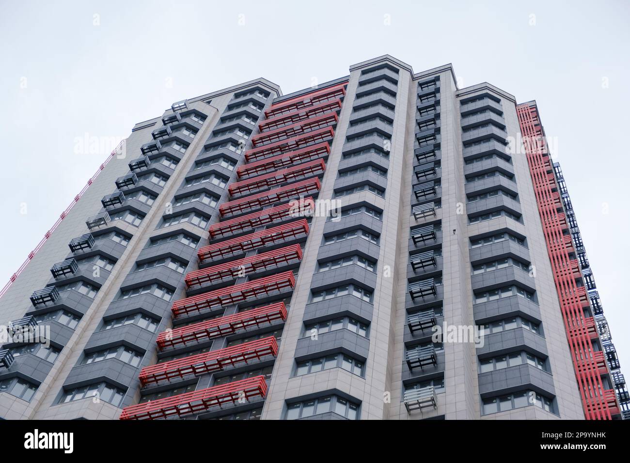 Modern high-rise building with balconies, set against clear sky. Image ...