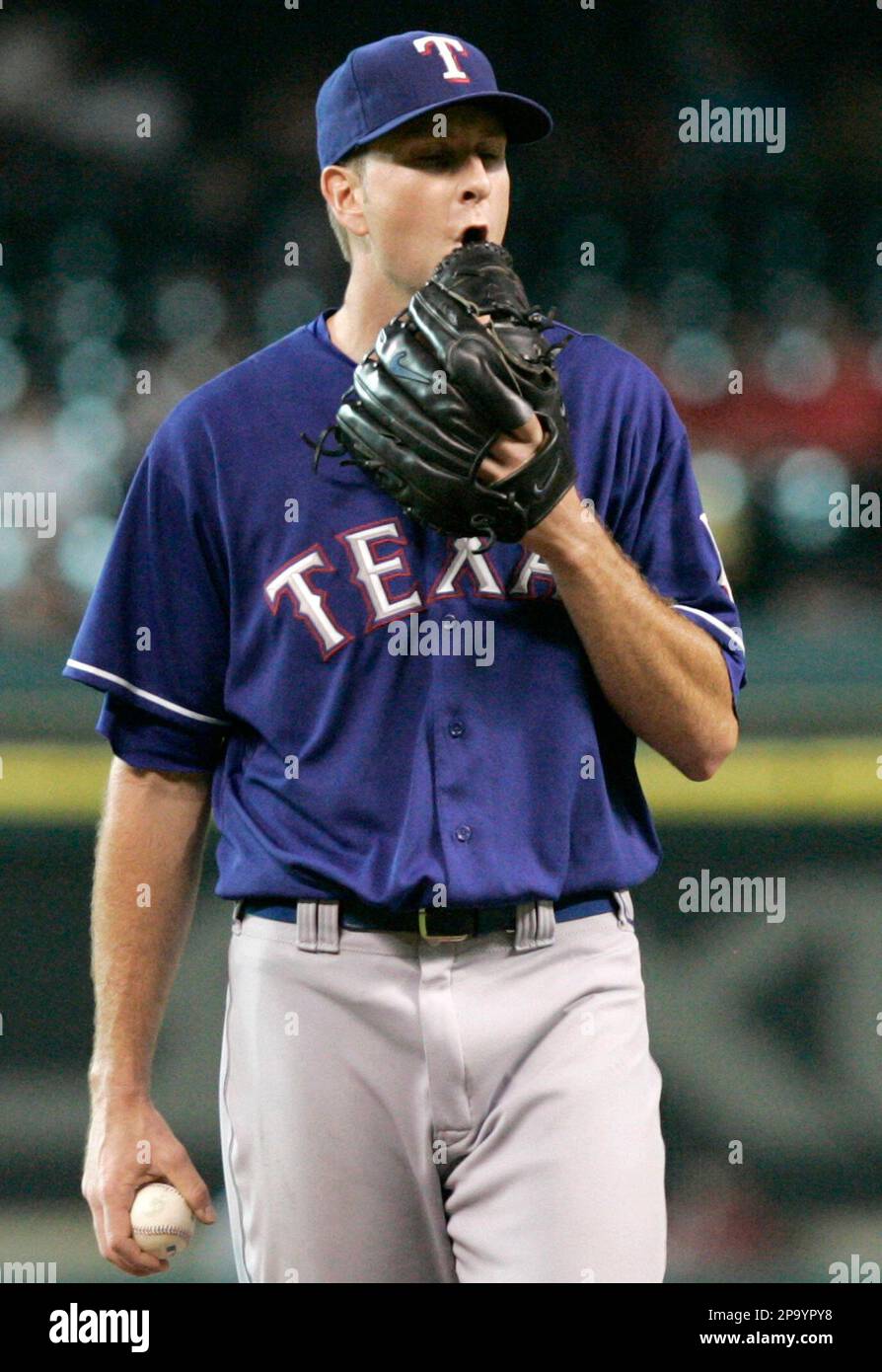 Texas Rangers starting pitcher Scott Feldman rubs his face after giving ...