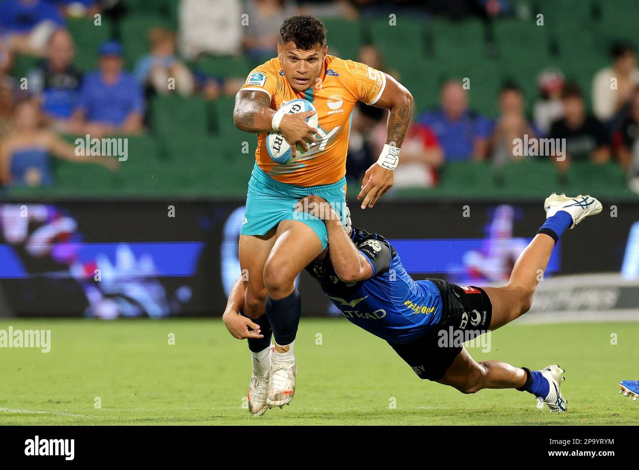 Levi Aumua of Moana Pasifika is tackled by Hamish Stewart of the Force ...