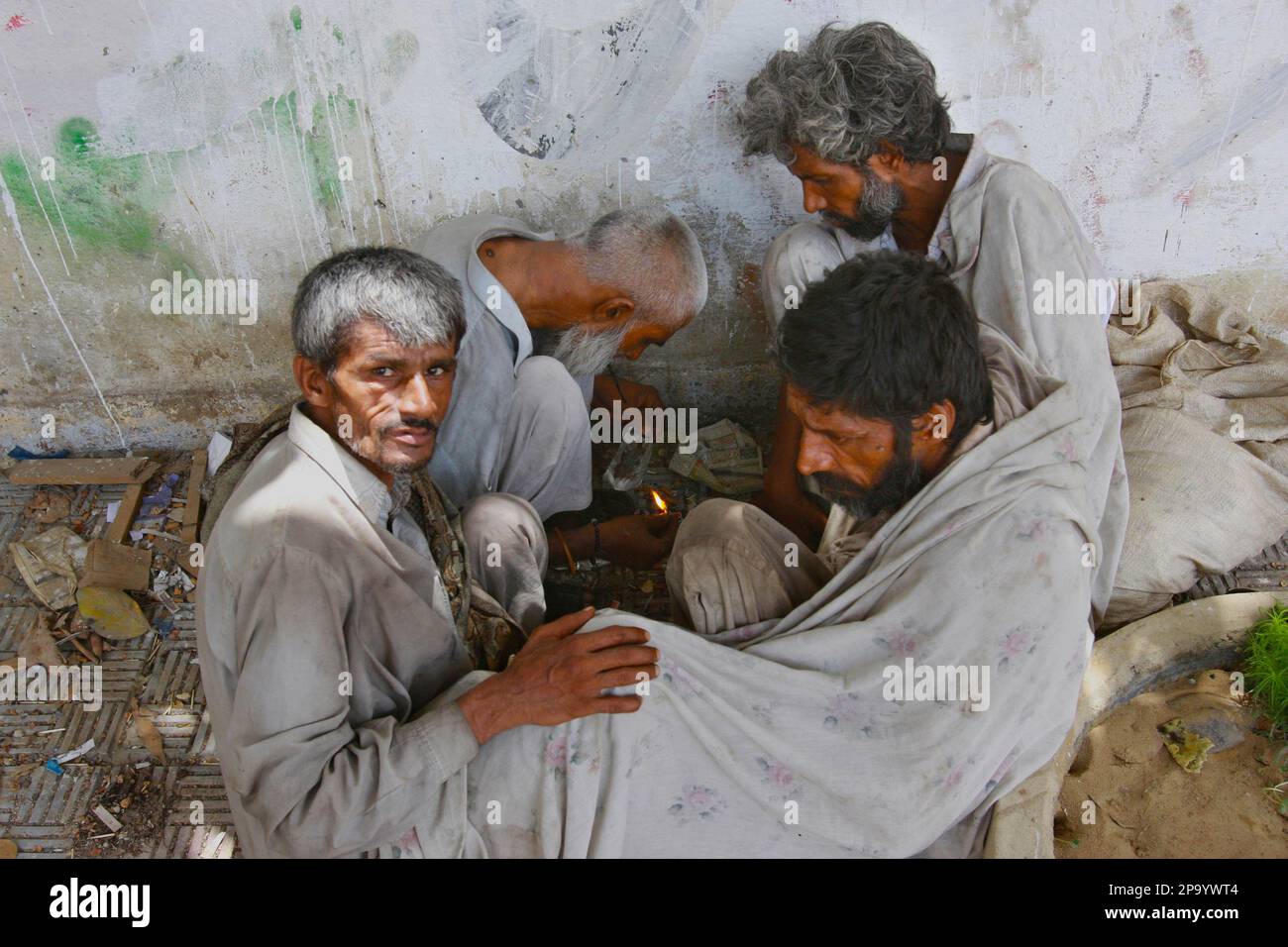 Pakistani drug addicts sit on a roadside as they prepare to smoke ...