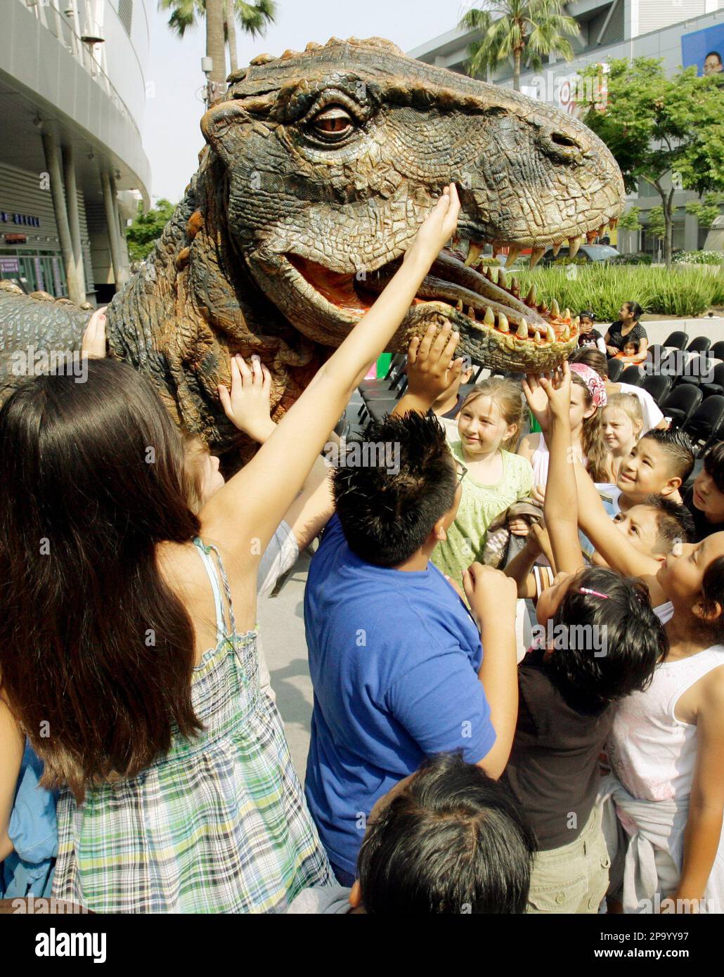 Children reach out to touch a realistic, life-size baby Tyrannosaurus ...