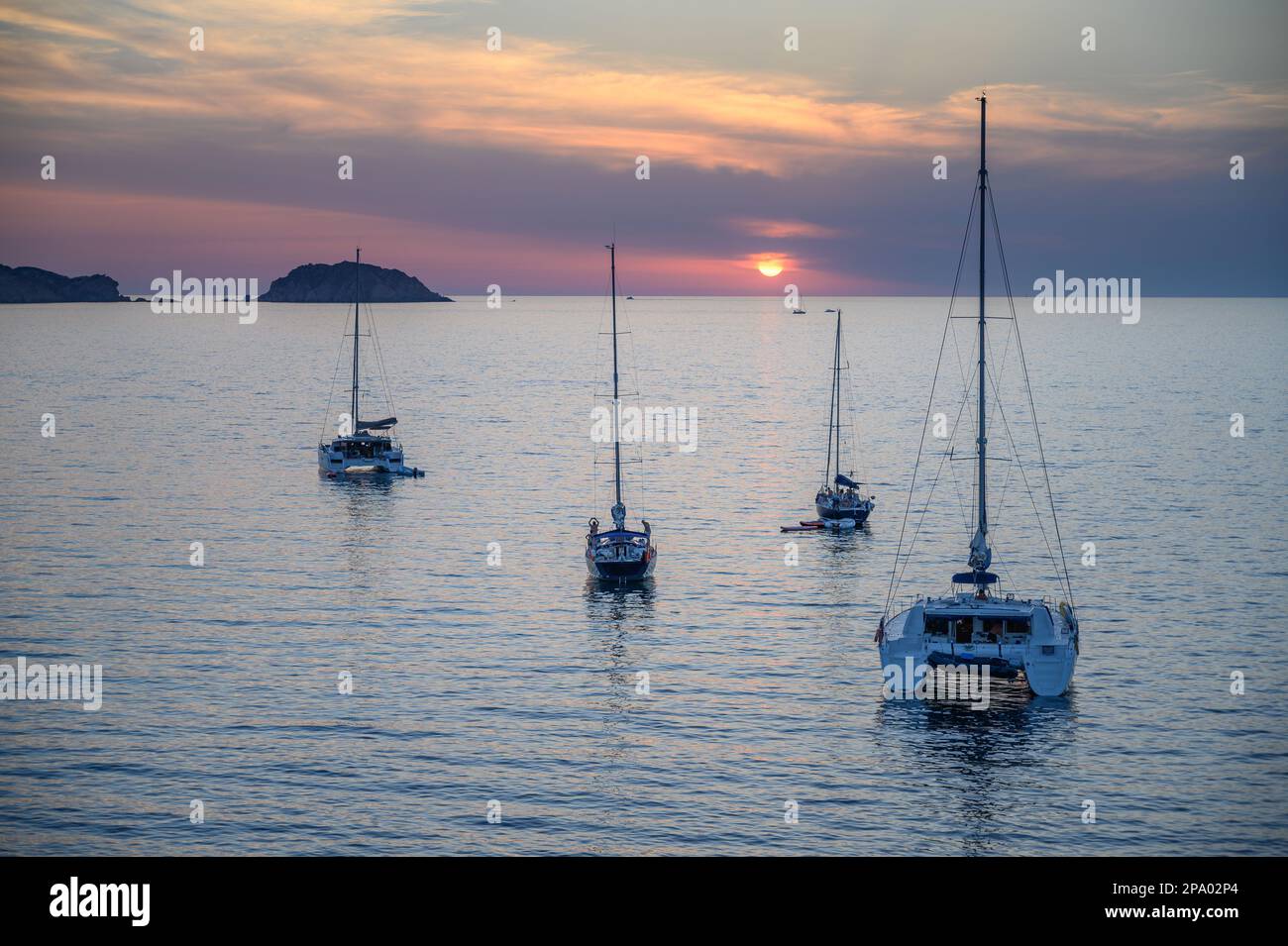 Sunset in the Mediterranean Sea, full of sailing boats and catamarans ...