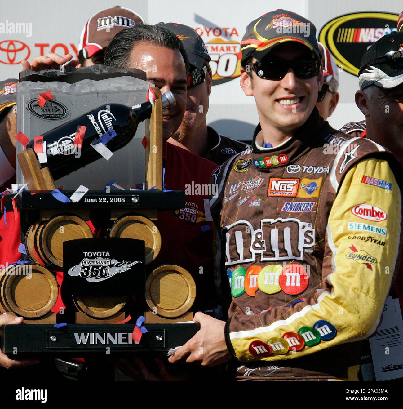 NASCAR driver Kyle Busch, right, holds the trophy after winning the ...