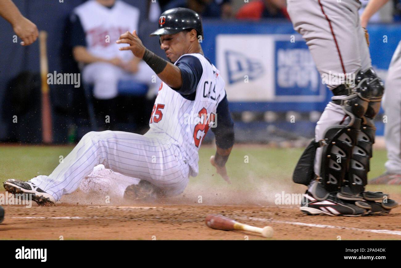 Minnesota Twins' Alexi Casilla scores after a hit by Justin Morneau against the Arizona ...