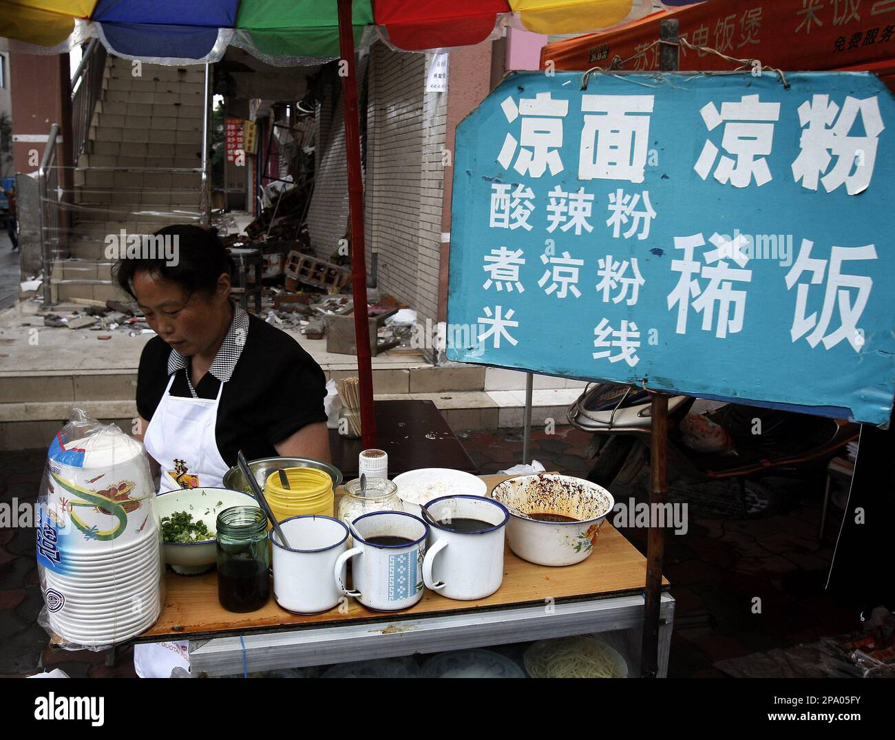 A vendor waits for customers behind her damaged food store following ...
