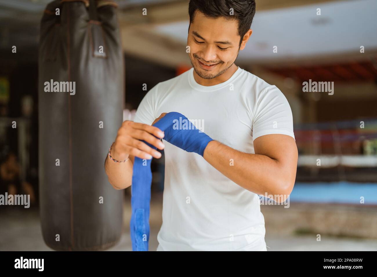 a asian male boxer wearing the boxing gloves while standing in ring ...