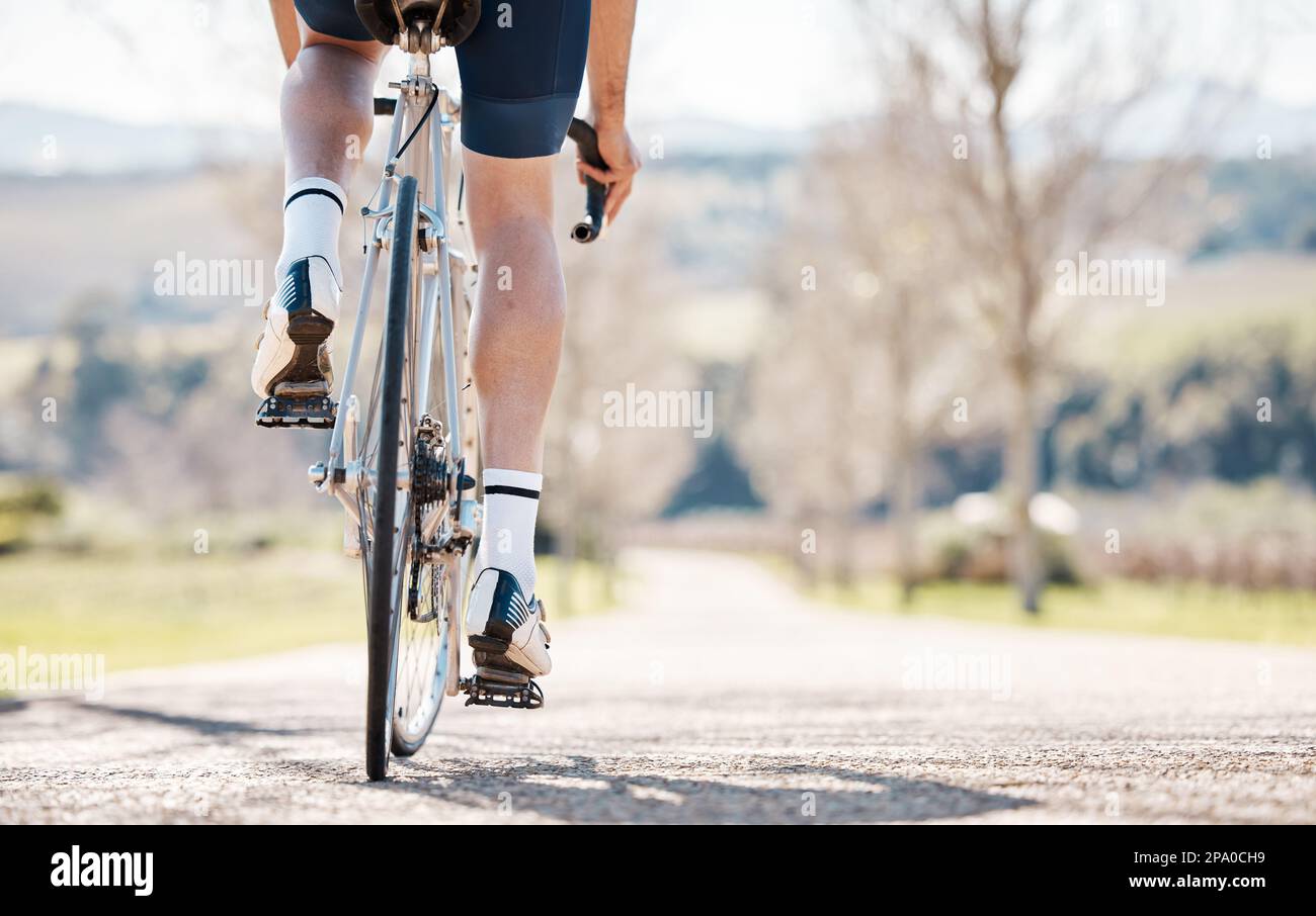 Back of man, bike wheel and park path for fitness, training and ...